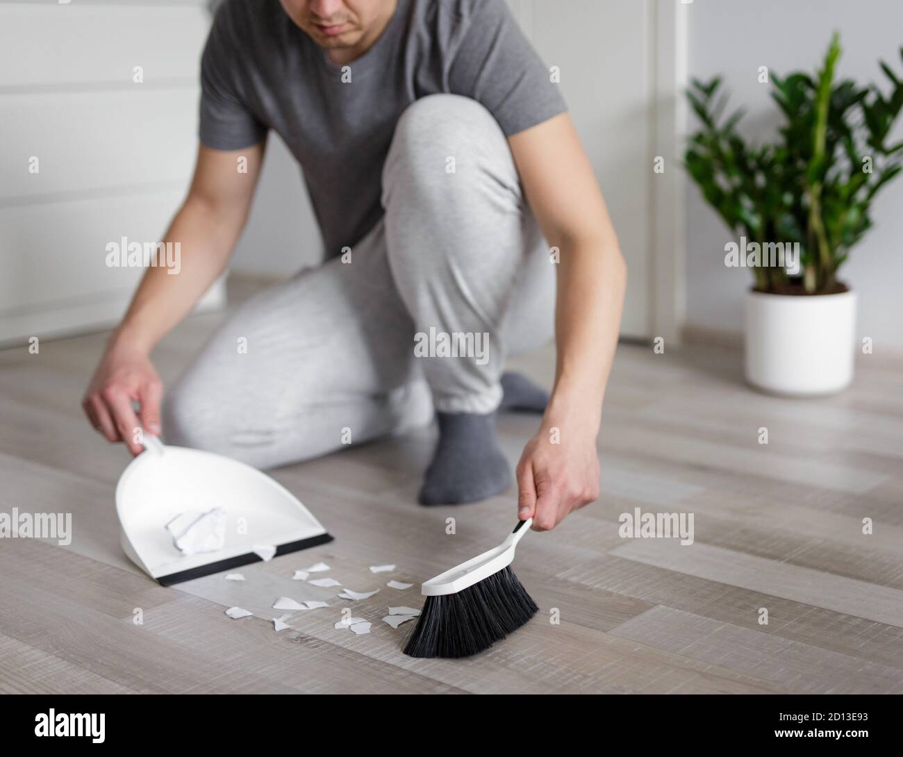 Man sweeping floor dustpan broom hi-res stock photography and images ...