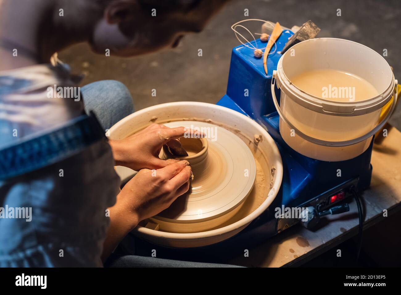 beautiful hands of a young girl, stained with clay when modeling a pot ...