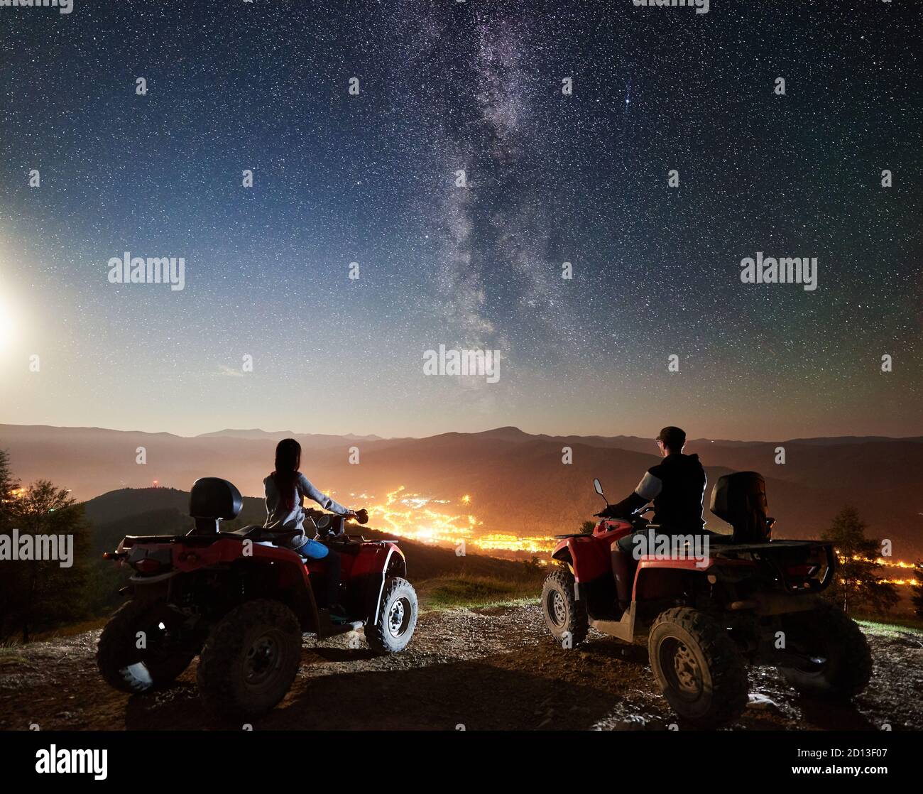 Back view of man and girl trevelers riding on atv quad motorbikes on ...