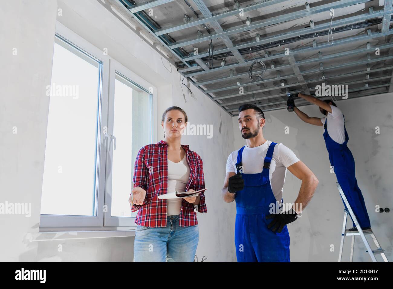 A female customer evaluates the work of a construction crew and talks ...