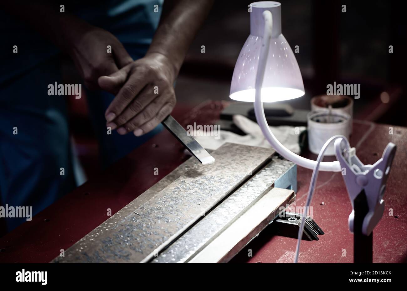 Industrial worker perform hand scraping slide way of the old bed ...