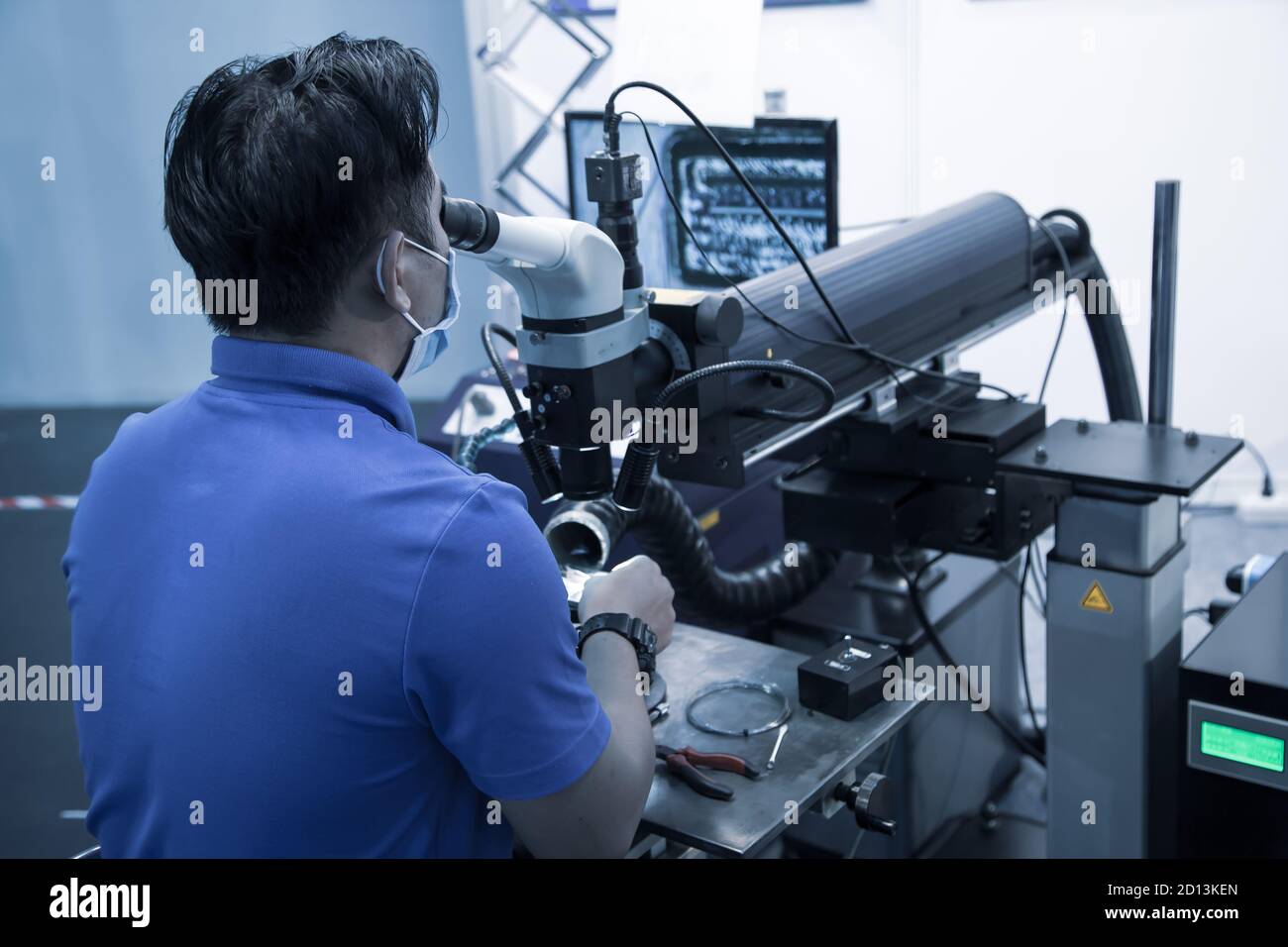 Industrial professional wearing face mask operating laser welding ...