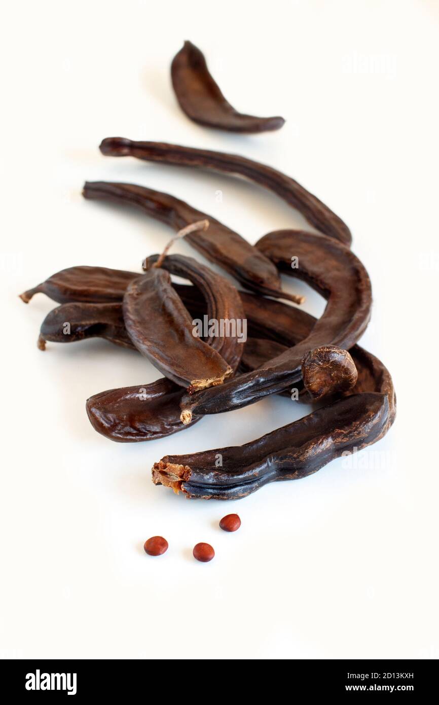Dry carob pods and seeds close up isolated on white Stock Photo - Alamy