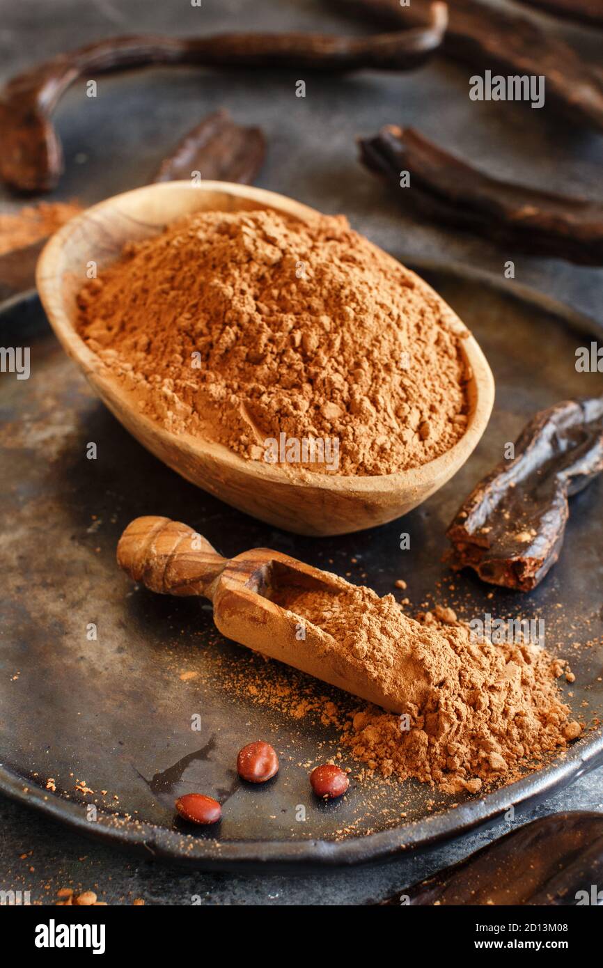 Dry carob pods and powder close up on a grey table Stock Photo - Alamy