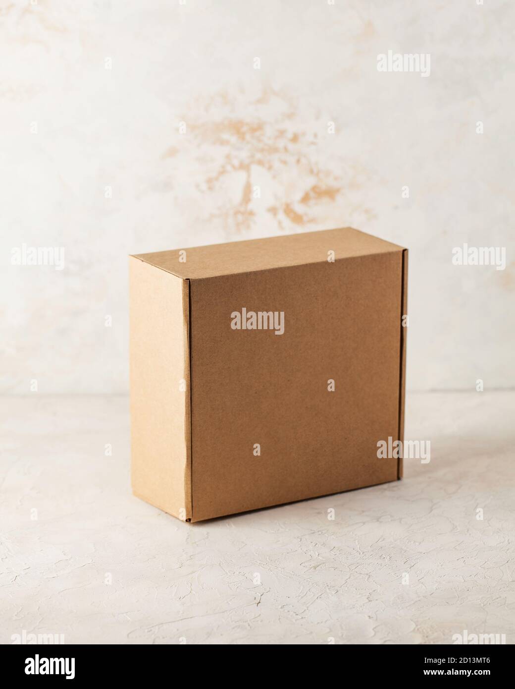 Side view of square closed Kraft cardboard box on a white background ...