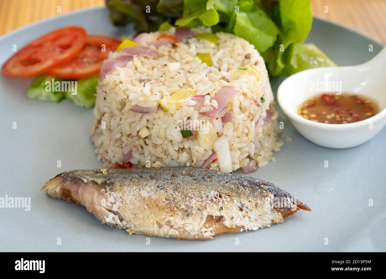 Mackerel fried rice is placed on a plate in a restaurant. Which is a ...