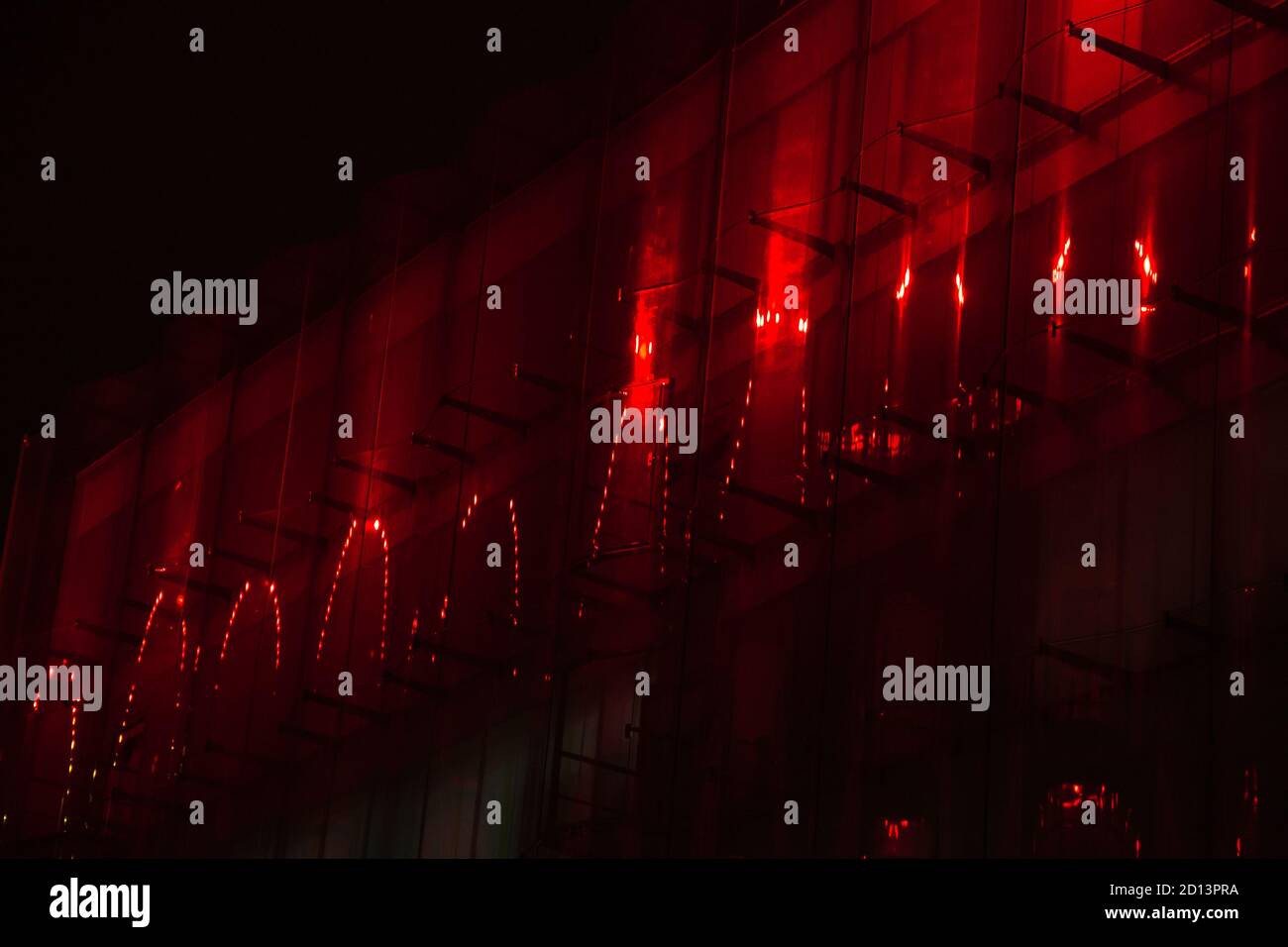 Neon red lights illumination over glass metal building. Futuristic ...