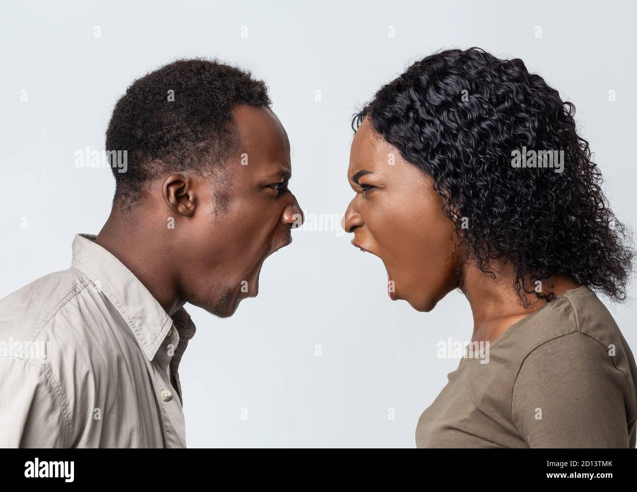 Black man and woman fighting over grey background Stock Photo - Alamy