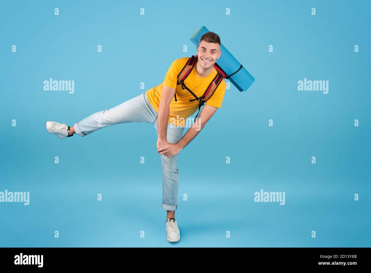 Full length portrait of happy young man with camping equipment dancing ...