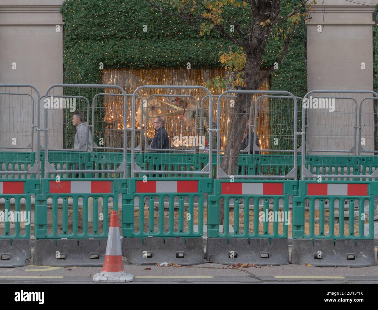People seen walking behind barriers set around renovation work of the ...