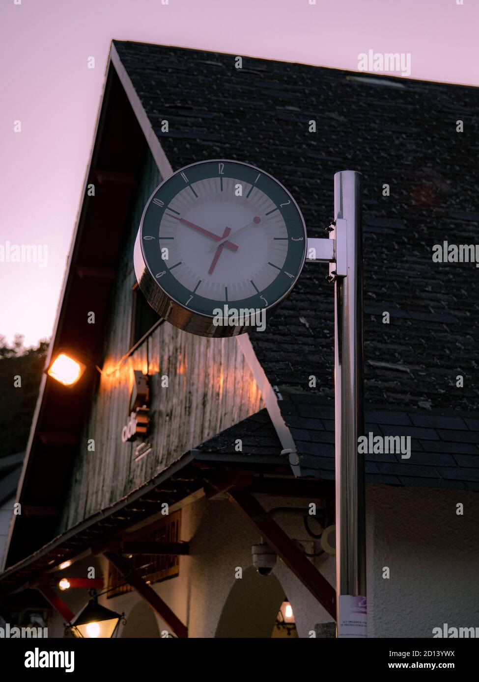 Closeup of a street clock against shingle roof building Stock Photo - Alamy