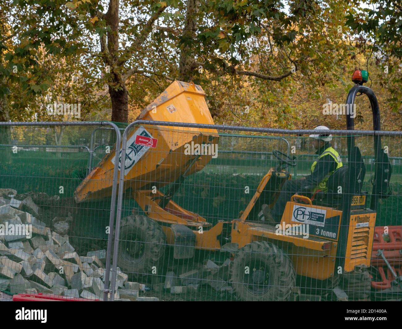Worker seen dumping large stones in an enclosed area during building ...