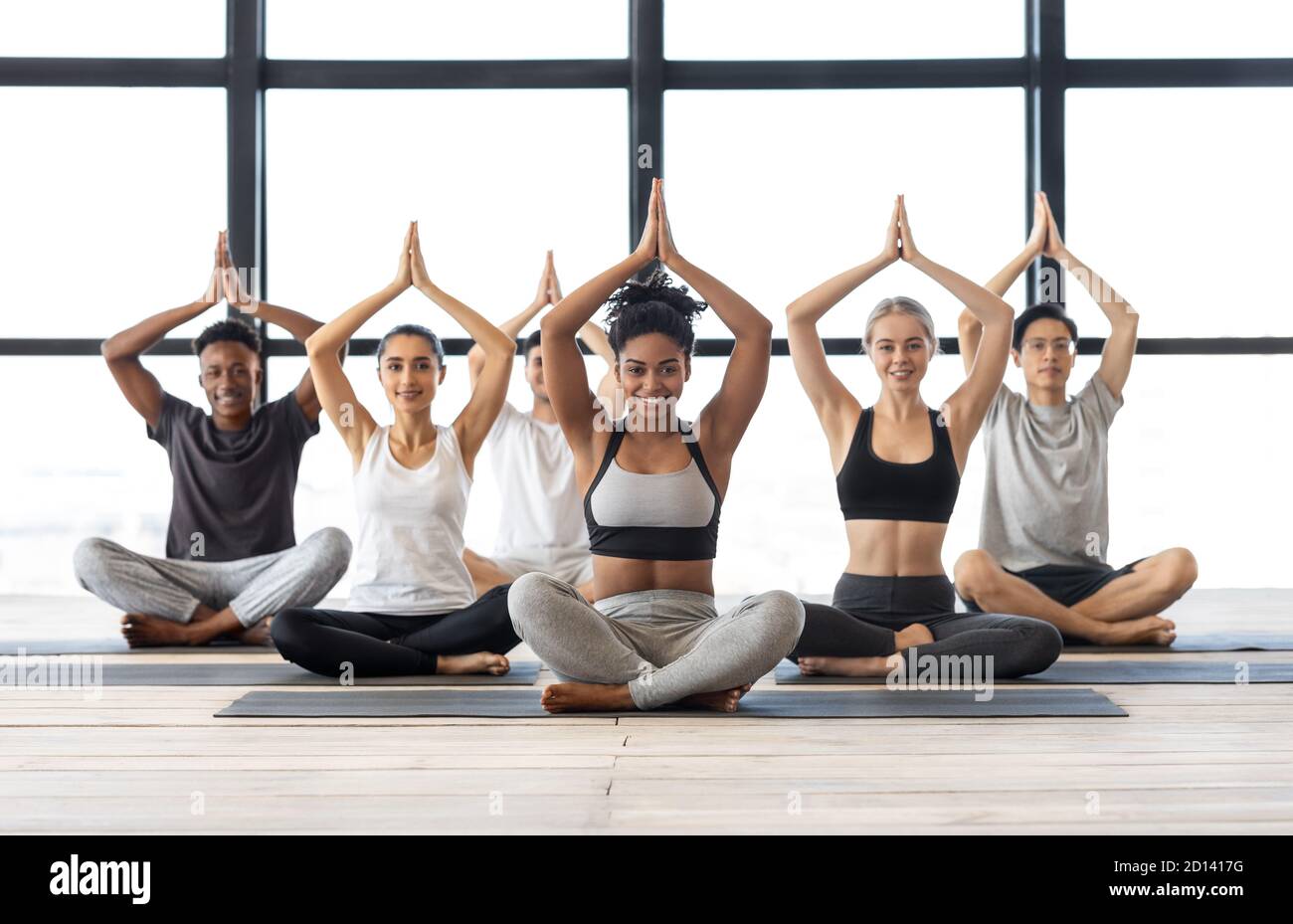 Group Of Yoga Enthusiasts Practicing Asanas In Modern Lost Studio Stock ...