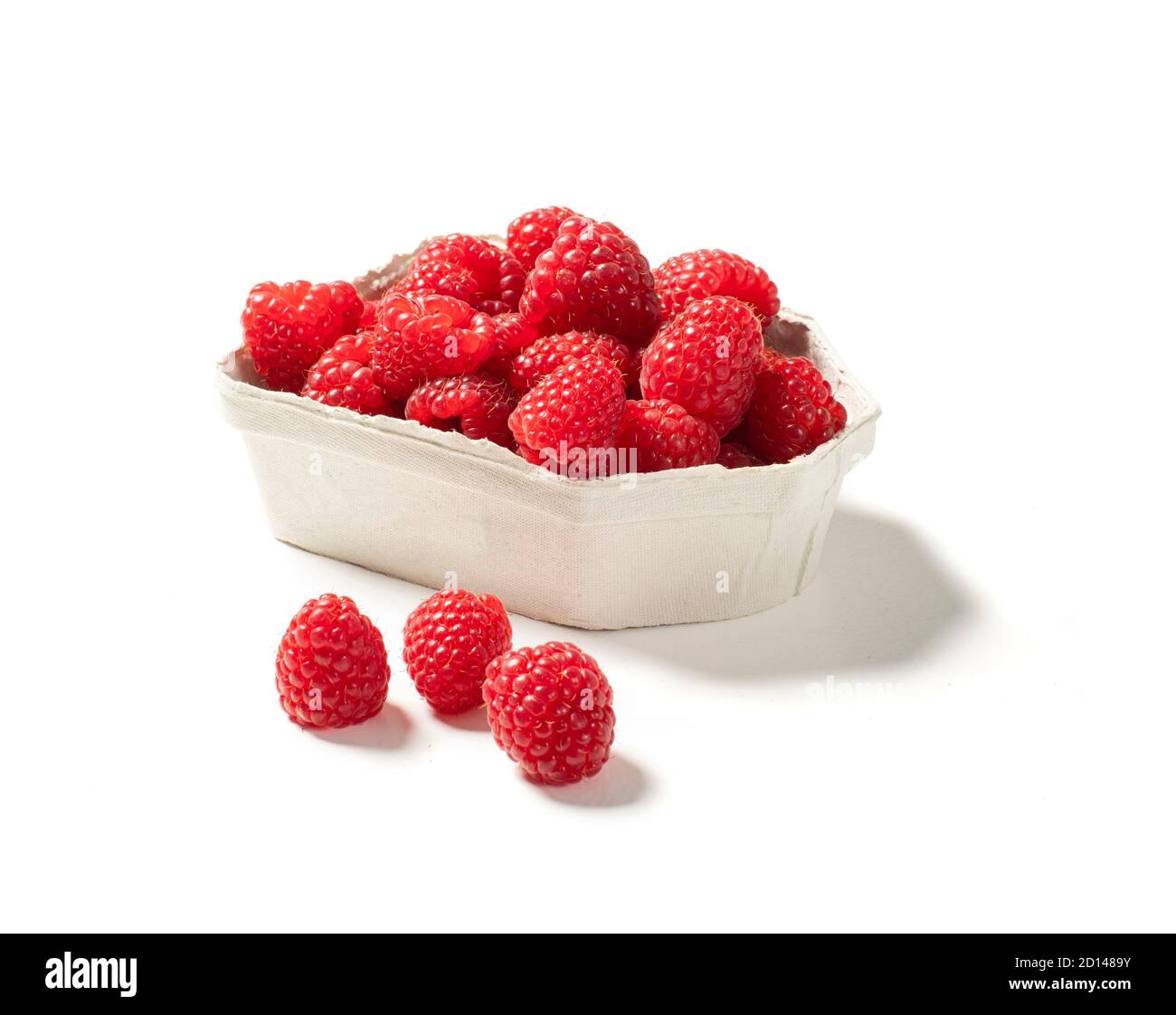 Tiny box with raspberries, (approx 250 gram) on a white table. Three ...