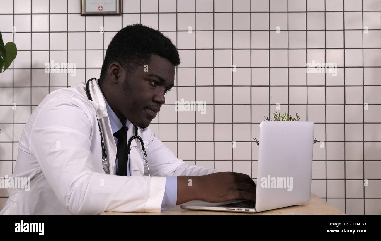 Doctor working on desk with laptop computer Stock Photo - Alamy