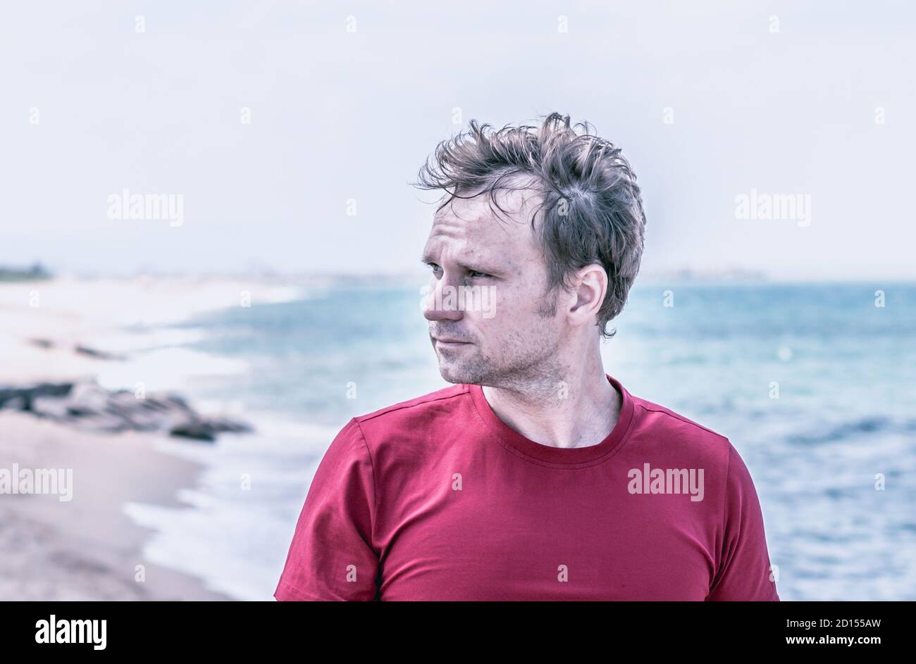 Serious handsome fair hair fluttering wind man red shirt, stubble face ...