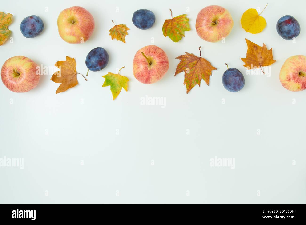 Hello september. autumn flat lay with leaves, plums and apples on white ...