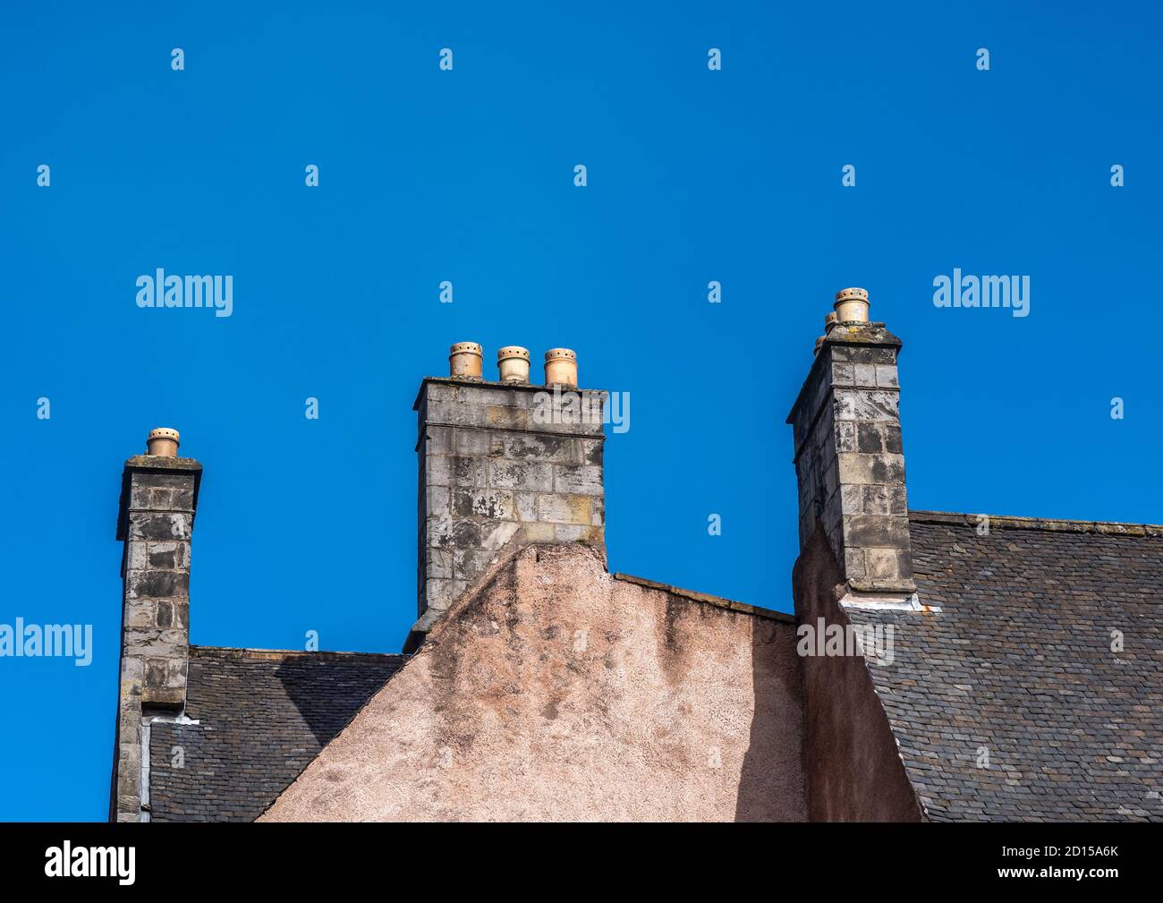 Veiw of rooftop chimney stacks stone built with blue sky background ...