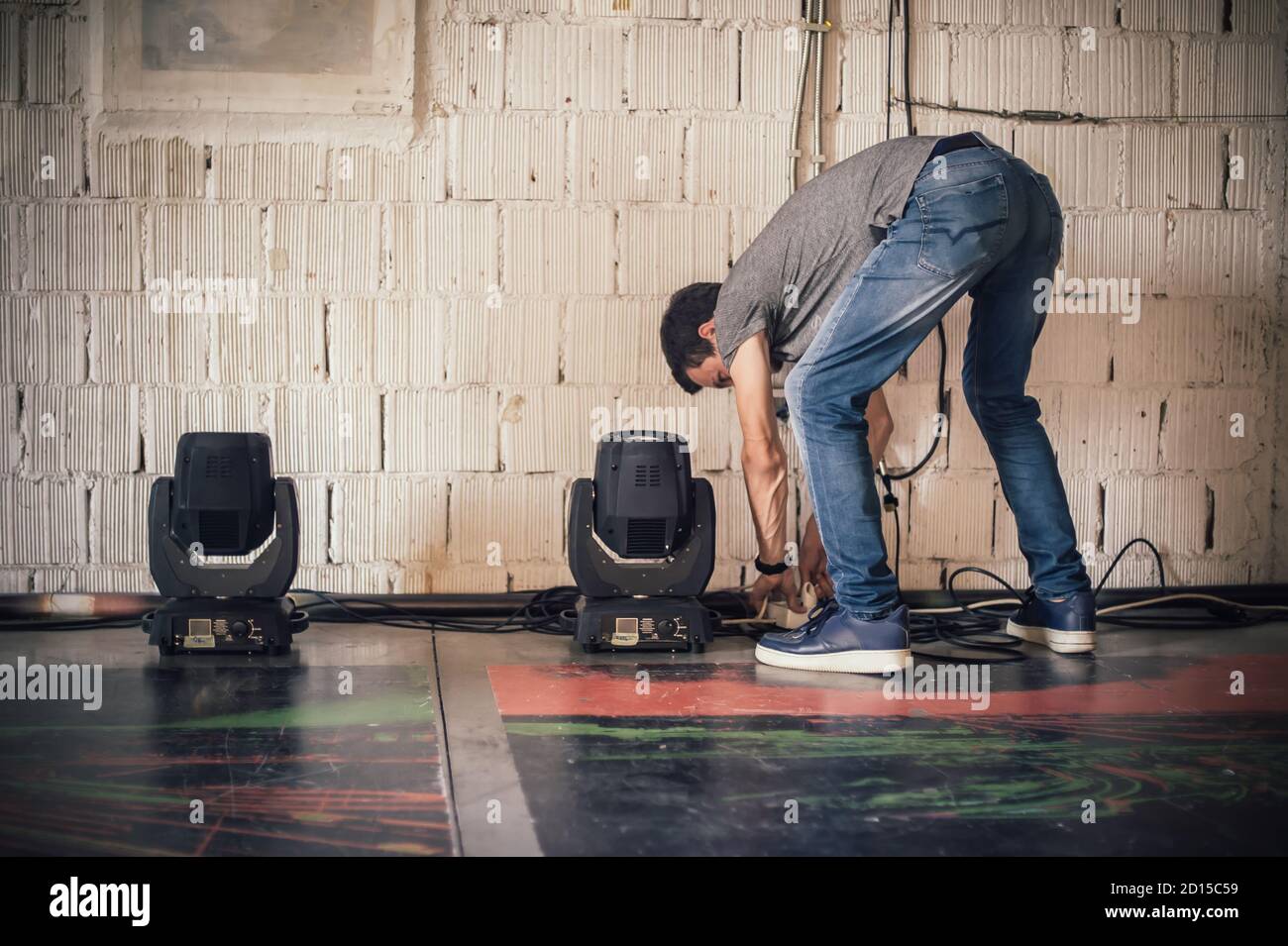 Theater lighting technician electric engineer adjusting focus of ...