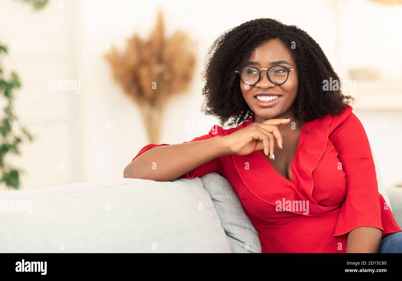 Black woman relaxing at home on the sofa Stock Photo - Alamy