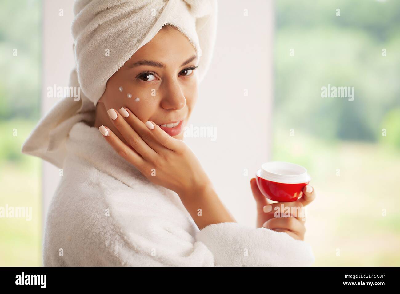 Skin care, beautiful model applying cosmetic cream treatment on her ...