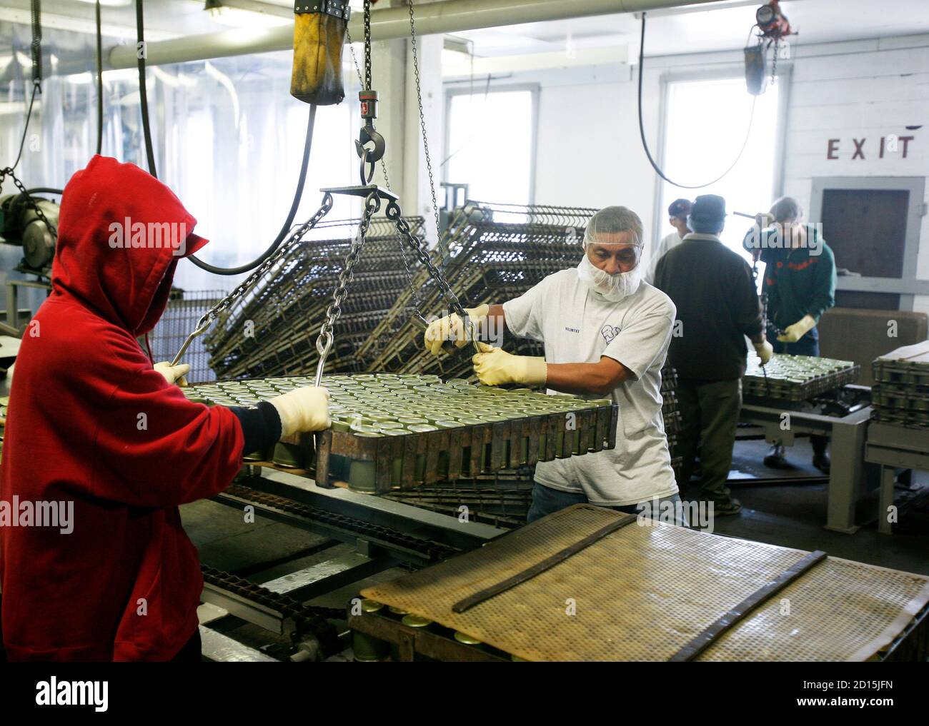 Workers move pallets of canned salmon to be cooked at the Alitak ...