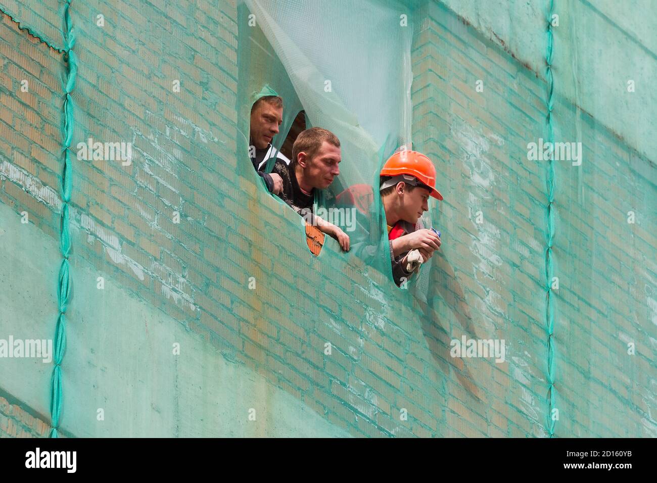 Russia. Moscow. Builders look out of the window of a building under ...