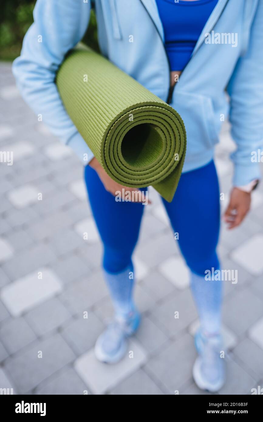 Close-up woman holding roll fitness after working Stock Photo - Alamy