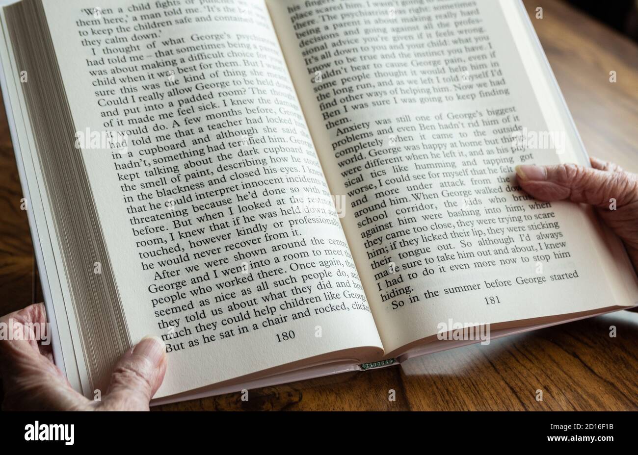 Elderly woman with impaired sight reading large print library book at ...