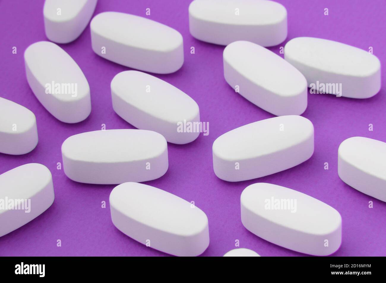 pharmacy industry concept of many white tablets pills on violet purple ...