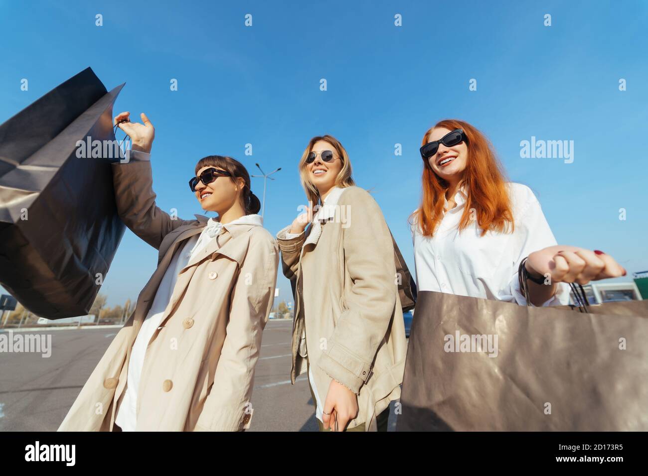 Young women with bags in hands posing for the camera Stock Photo - Alamy