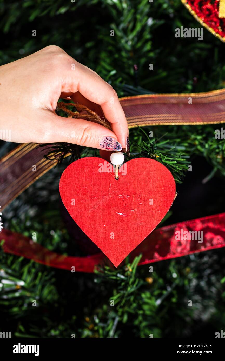 Decorating Christmas tree, hand putting Christmas decorations on fir ...