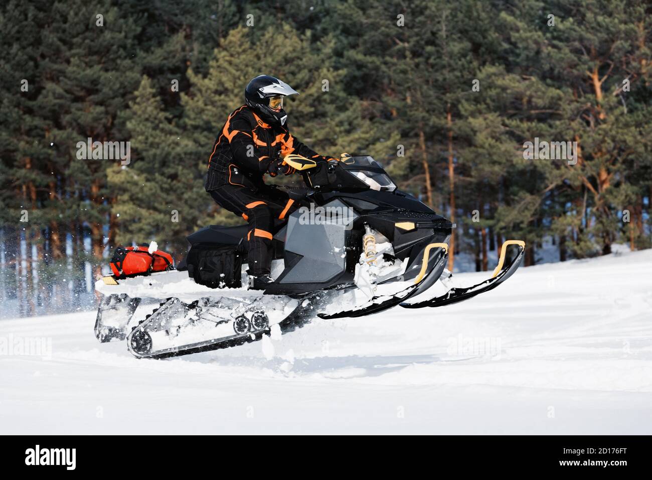 Snowmobile rider driving fast. Riding with fun in white snow powder ...