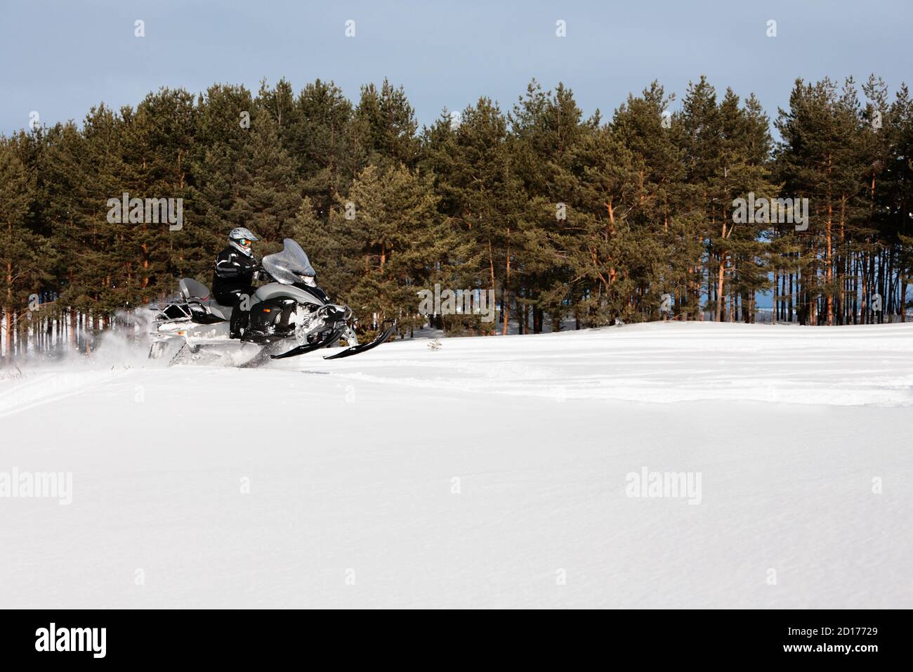 Snowmobile rider driving fast. Riding with fun in white snow powder ...
