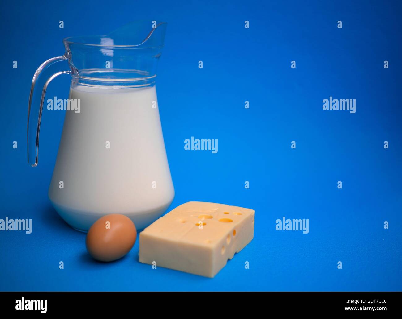 Dairy products. Milk, egg and cheese on a blue background Stock Photo ...