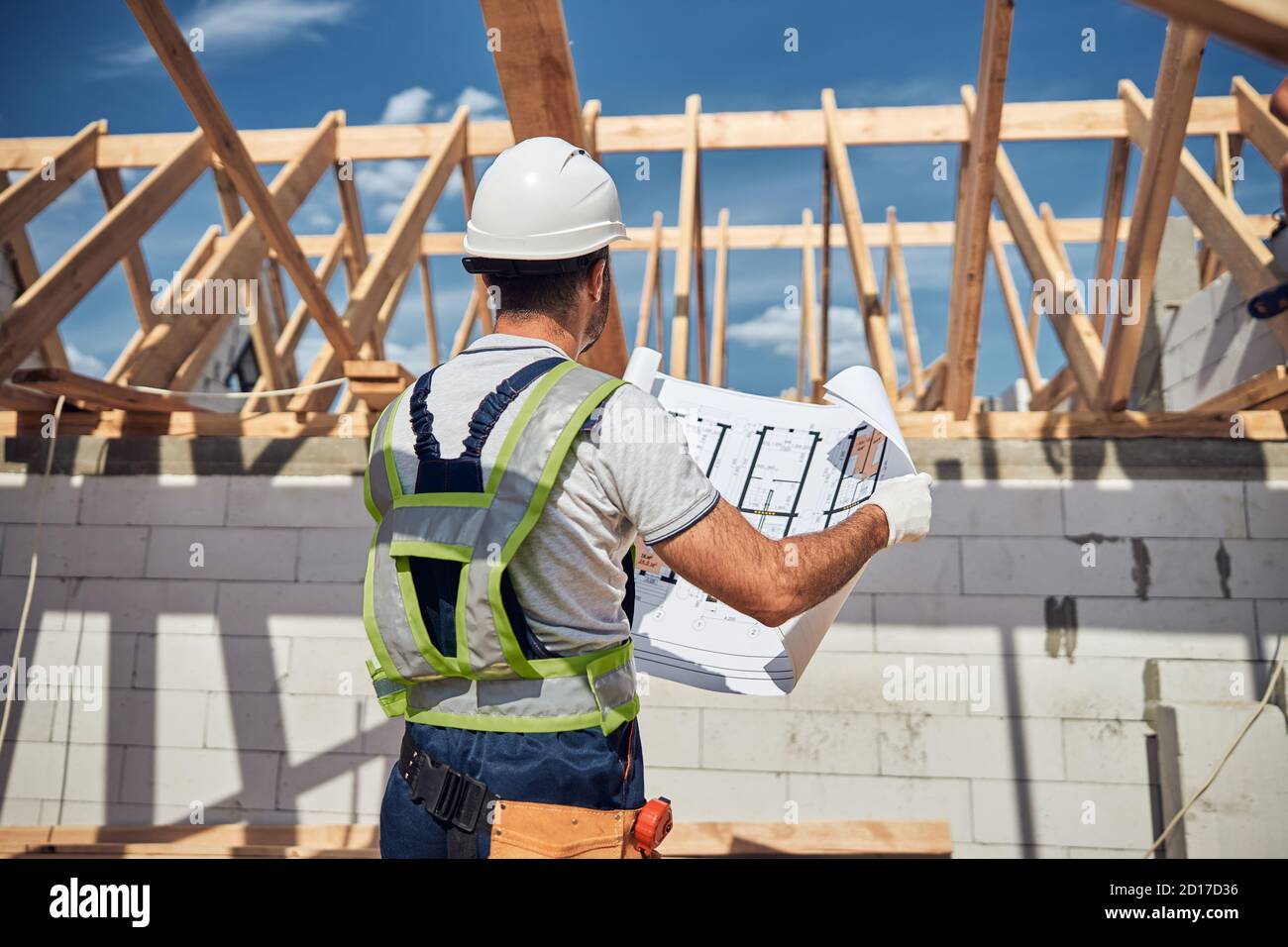 Competent builder checking drawing on the object Stock Photo - Alamy