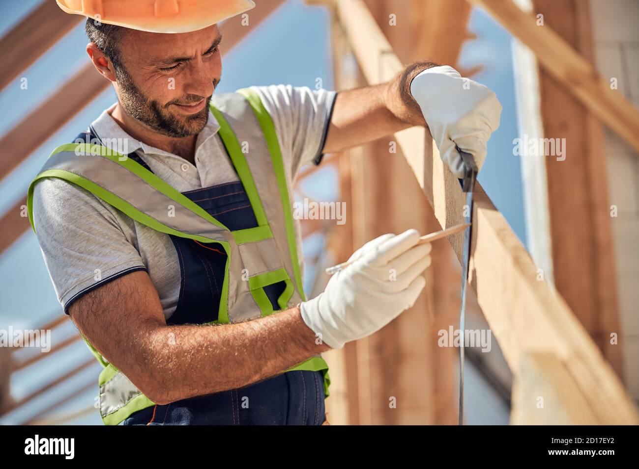 Positive delighted constructor making mark on the beam Stock Photo - Alamy