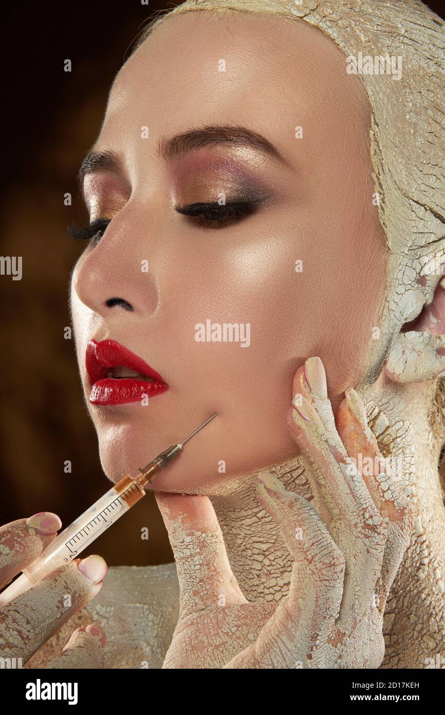 Girl with creative makeup makes herself injections in the face Stock ...