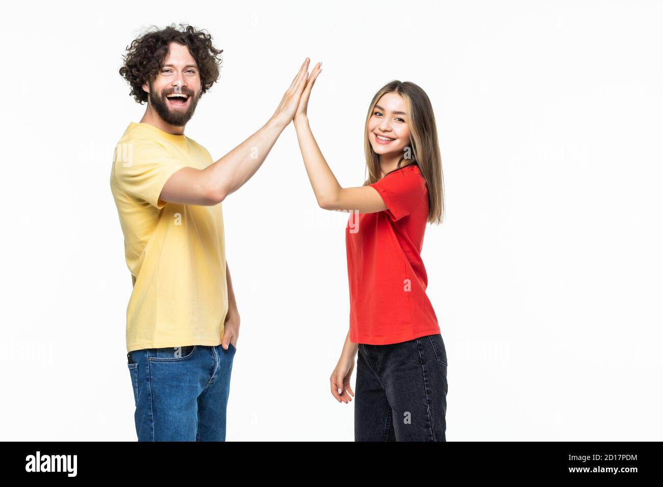 Portrait of a beautiful young couple standing and giving high five ...