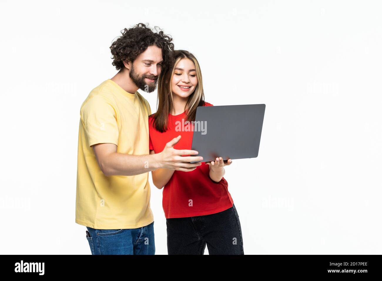 Attractive young couple holding their laptop on white background Stock ...