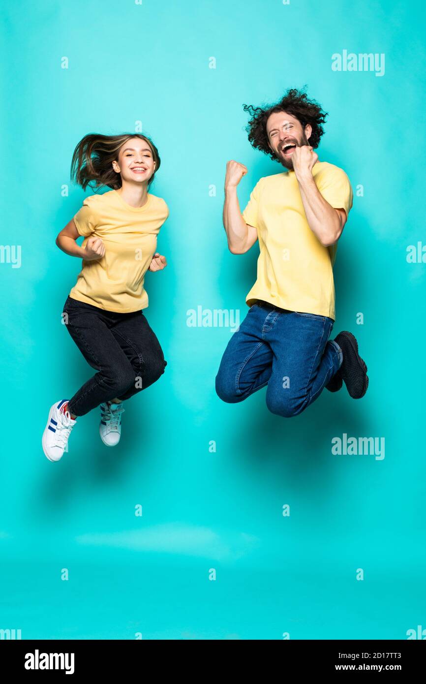 Attractive couple jumping in air having fun fooling rejoicing dancing ...