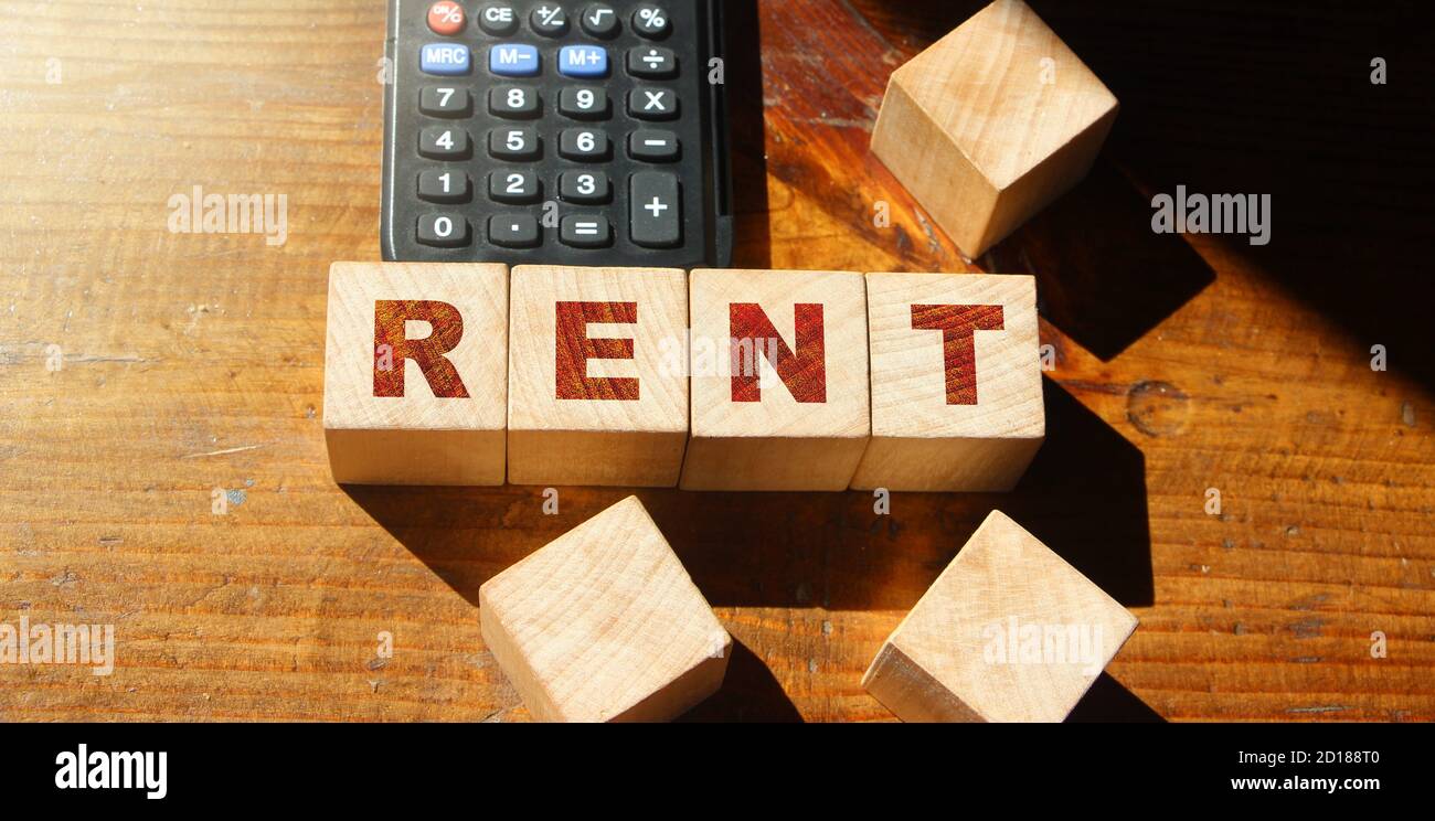 Concept word RENT on wooden cubes on a wooden background and calculator ...