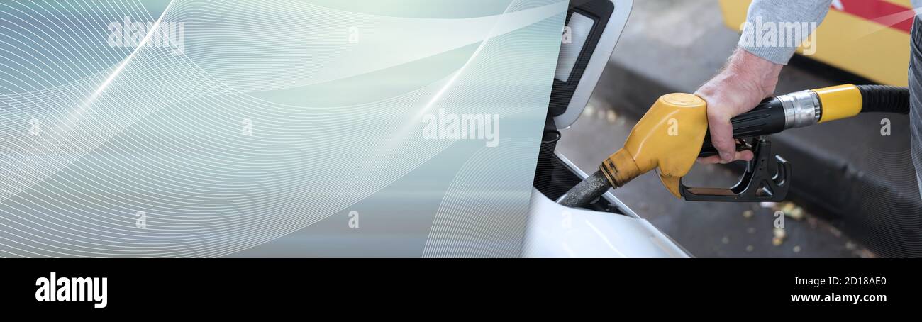 Hand holding yellow fuel pump nozzle and refilling car. panoramic ...