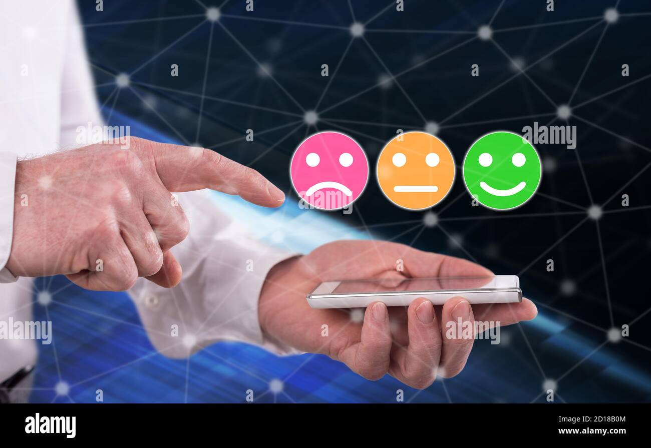 Customer satisfaction concept above a smartphone held by a man Stock ...