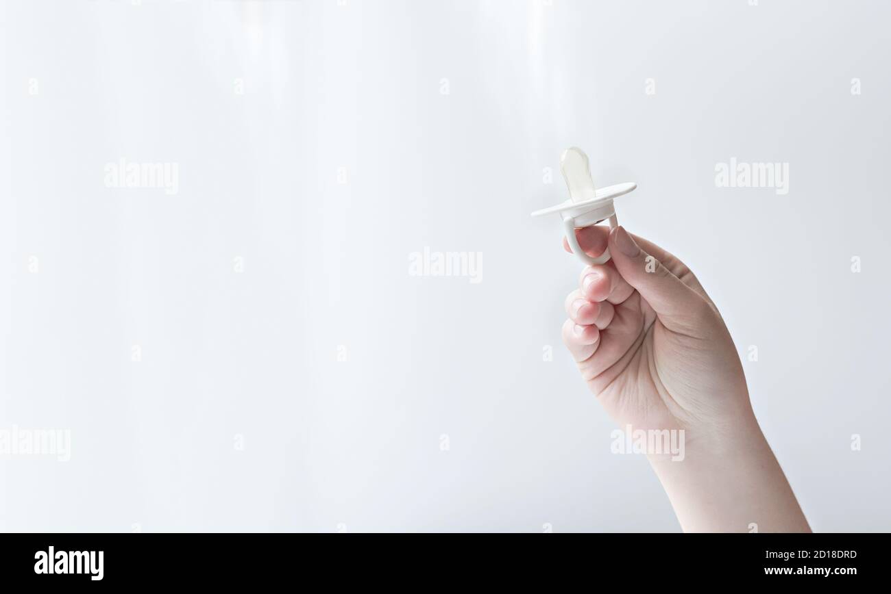 young woman's hand holding baby pacifier. mother's hand showing baby ...