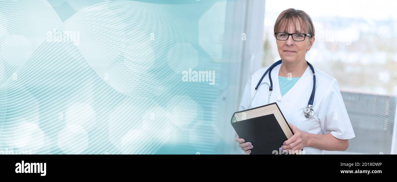 Portrait of female doctor standing and holding a medical textbook ...