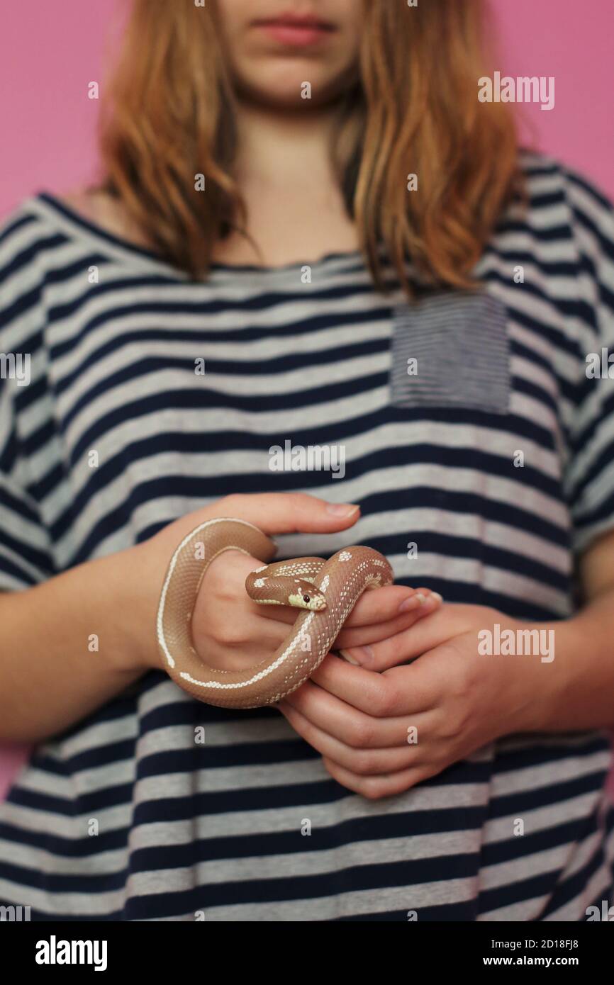 A teenage girl holding a snake Stock Photo - Alamy