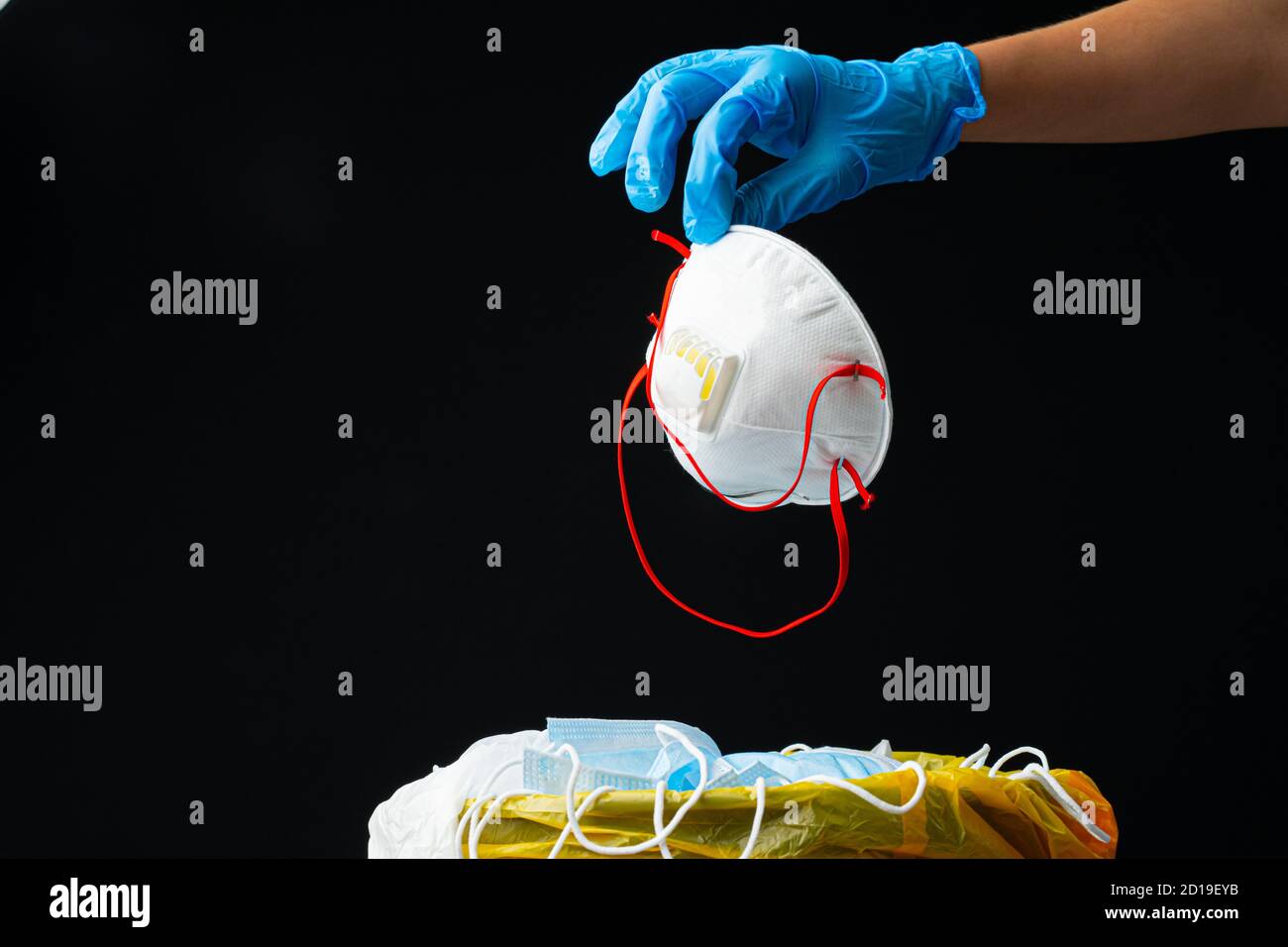 Hand putting used dirty surgical mask to a garbage bin Stock Photo - Alamy