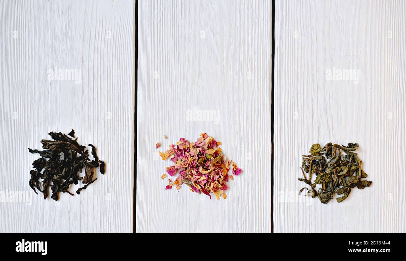 Different types of tea leaves on wooden background. Black, green and ...