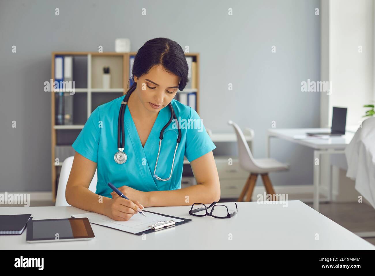 Doctor writing in patient chart hi-res stock photography and images - Alamy